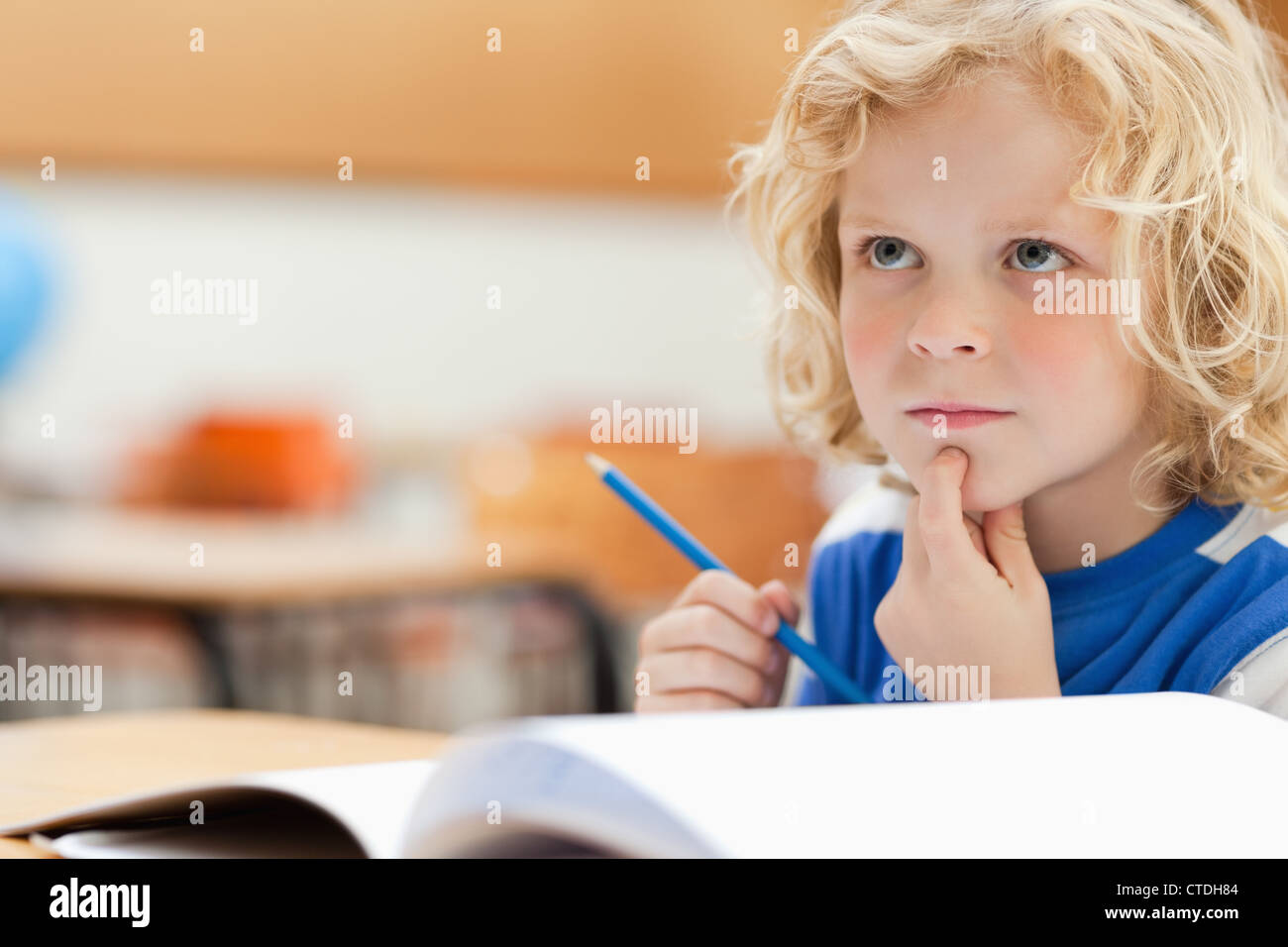 Thinking boy scratching his chin Stock Photo - Alamy