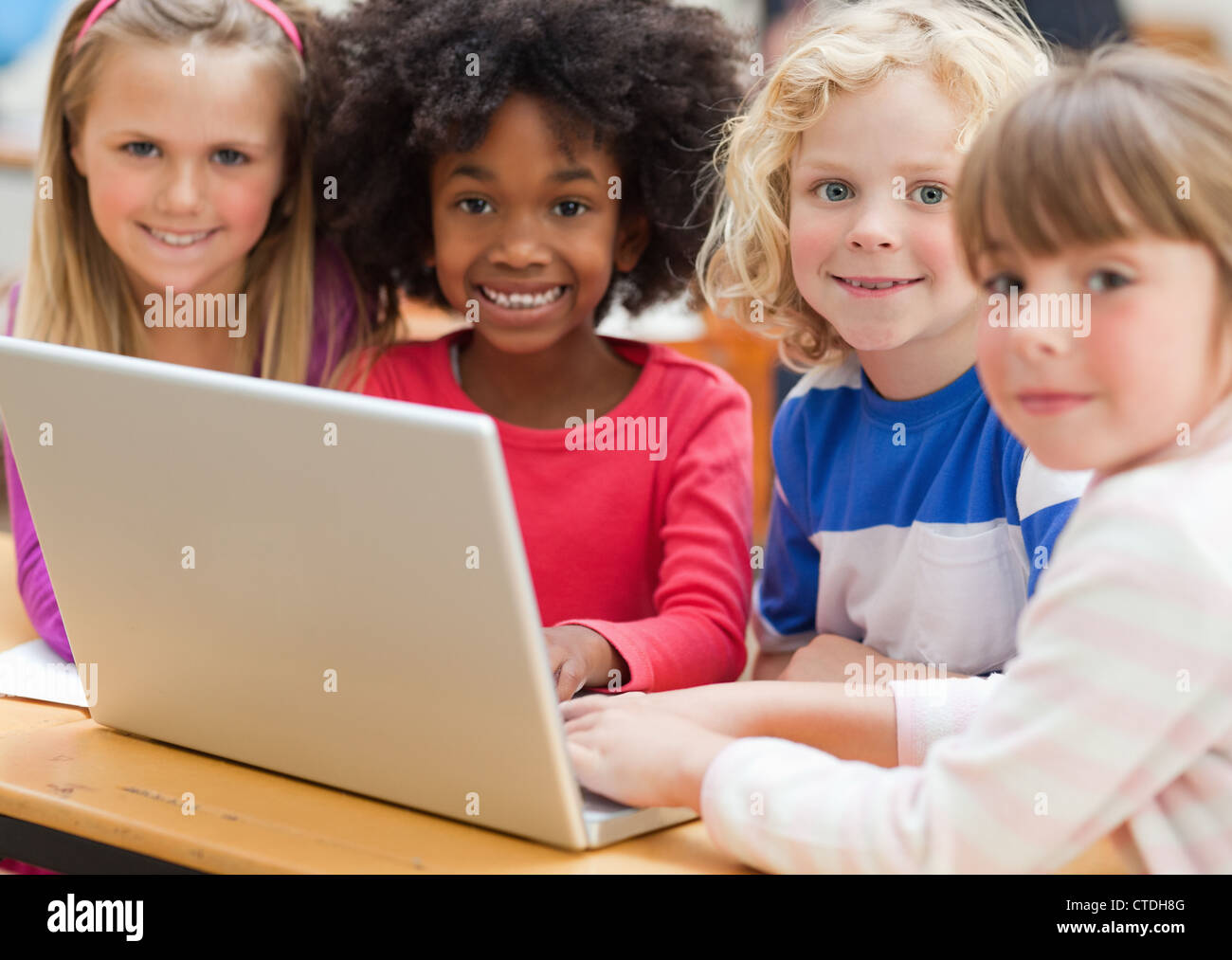 Smiling students with laptop Stock Photo - Alamy