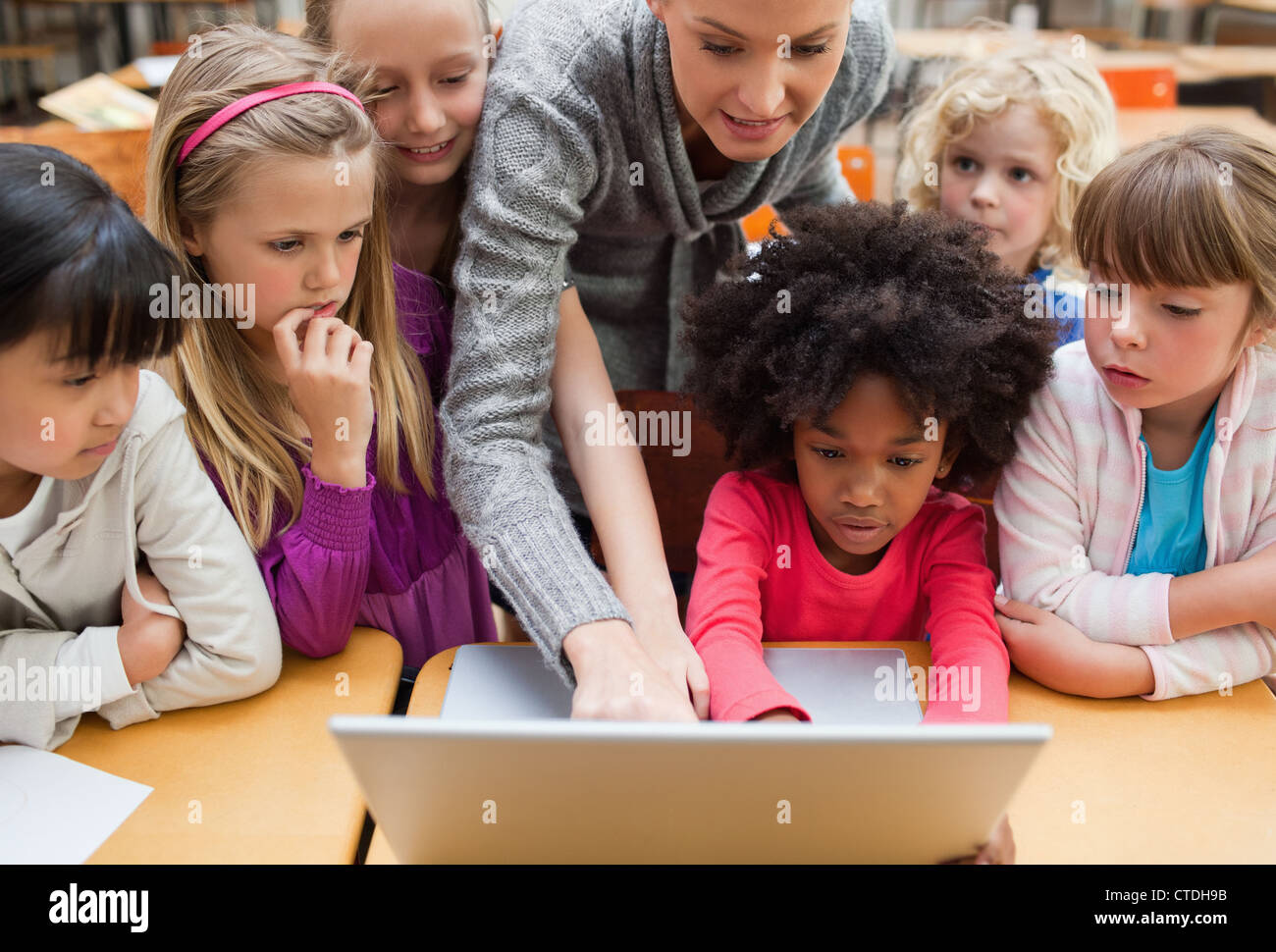 Teacher explaining laptop to students Stock Photo - Alamy