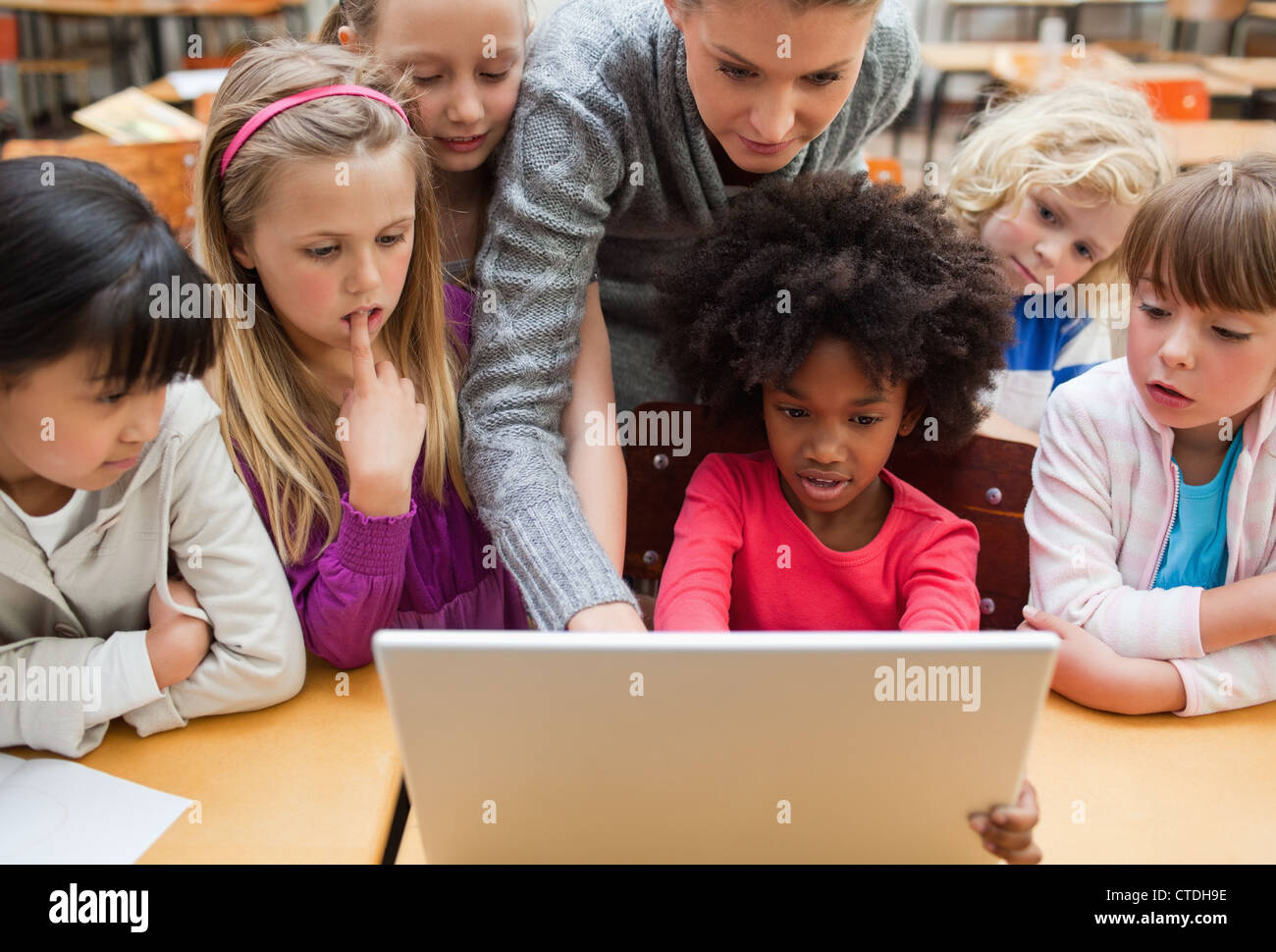 Teacher showing students laptop Stock Photo - Alamy