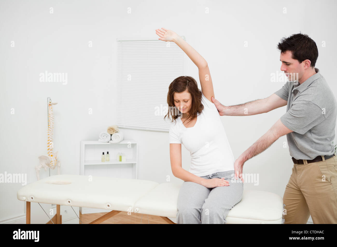 Physiotherapist insuring central alignment of spine Stock Photo - Alamy