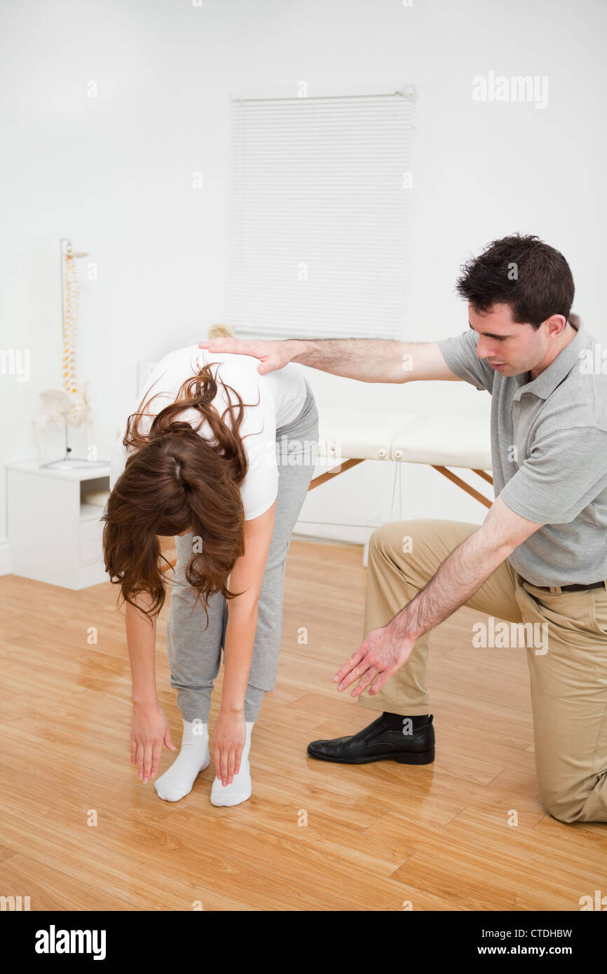 Doctor looking at a patient who is doing stretching exercises Stock ...