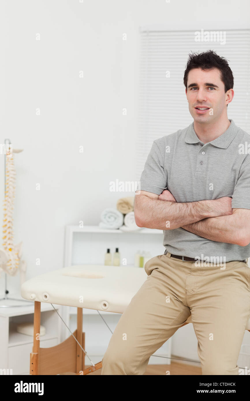 Peaceful osteopath sitting with arms crossed Stock Photo - Alamy