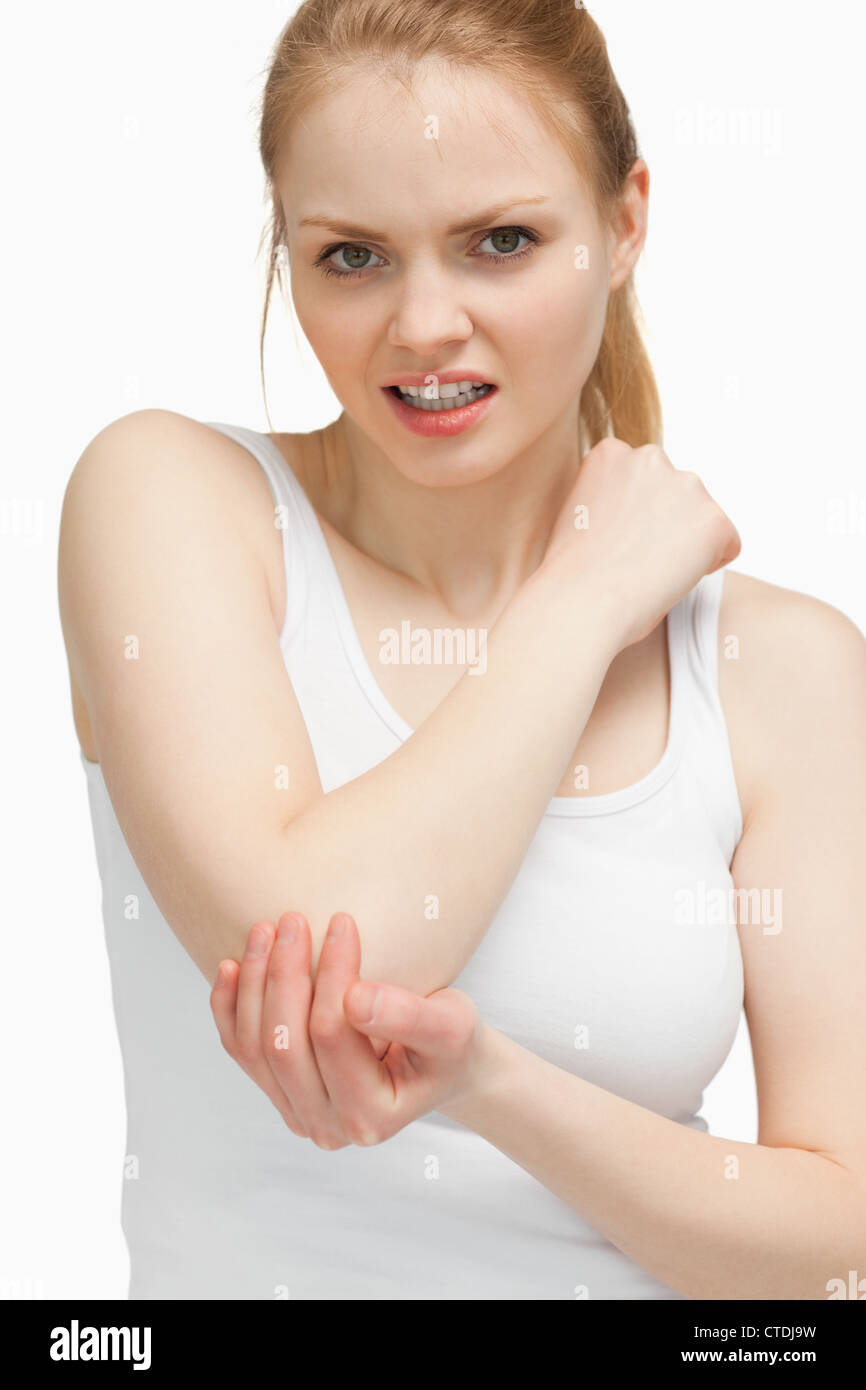 Blonde woman touching her painful elbow Stock Photo - Alamy