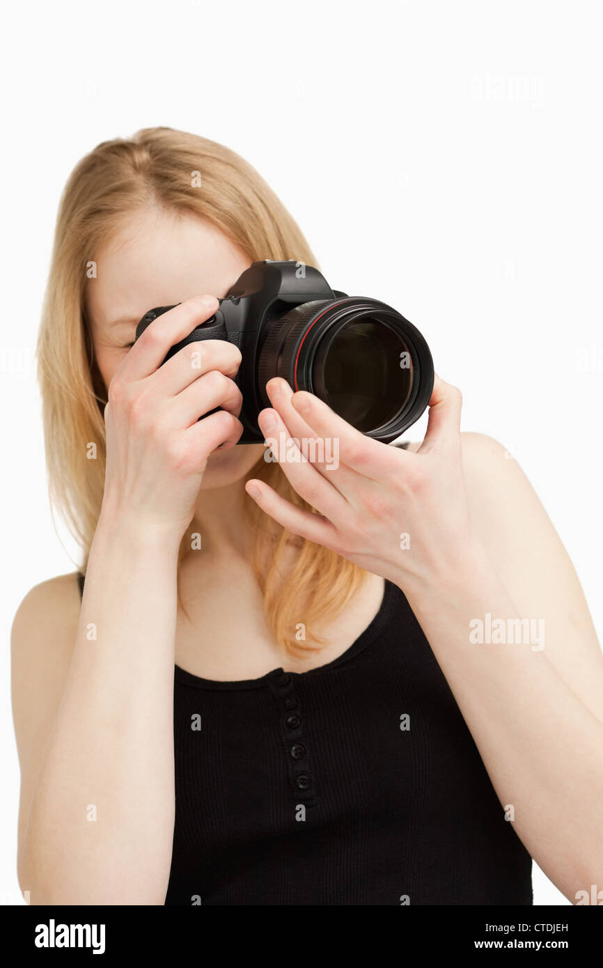Young woman aiming with a camera Stock Photo - Alamy