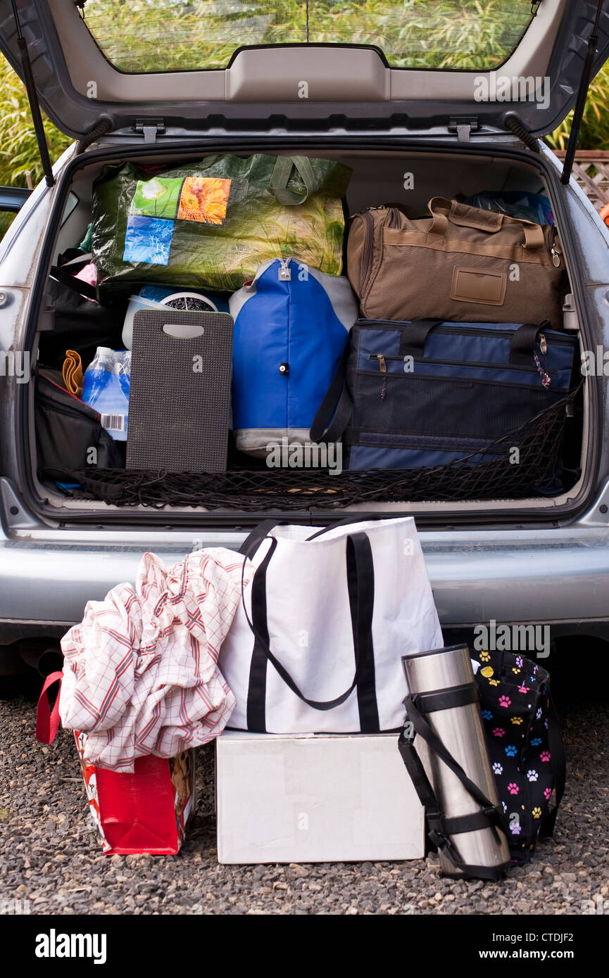 Family on vacation with their automobile packed with suitcases, bags ...