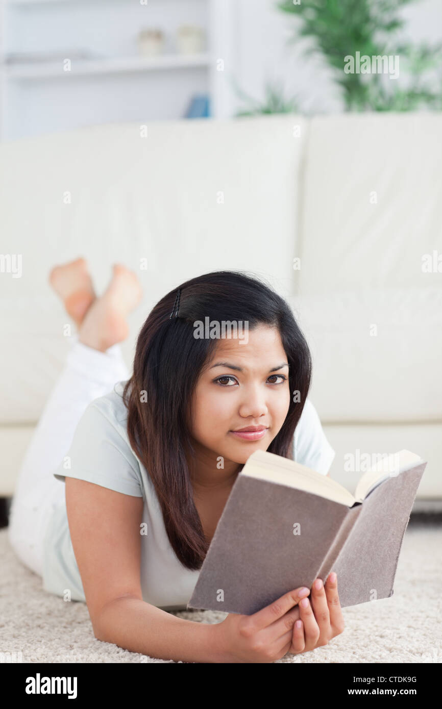 Woman lies on the floor as she reads a book Stock Photo - Alamy