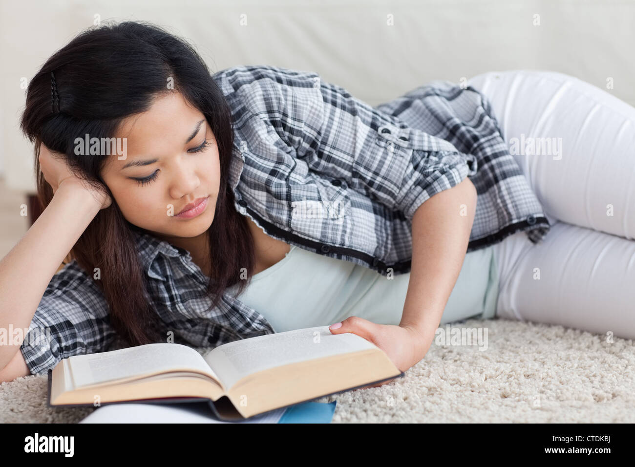 Woman reading a book as she lays on the floor Stock Photo - Alamy