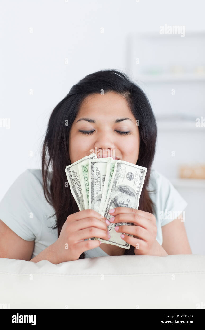 Woman closing her eyes as she holds some dollar bills Stock Photo - Alamy