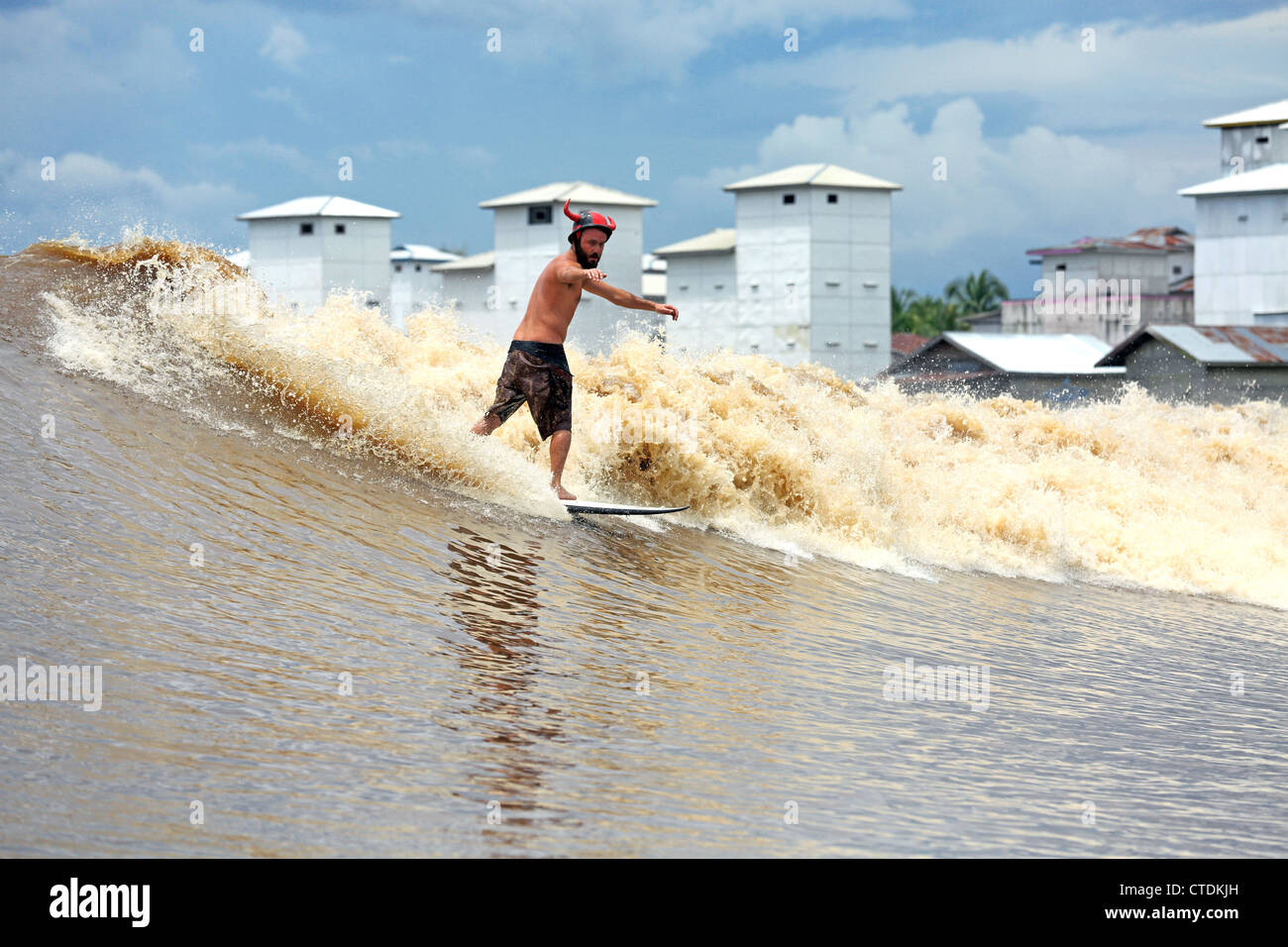 Man surfing past bird towers used in the birds nest soup industry on ...