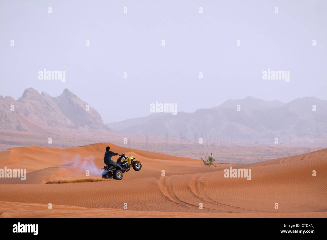 Quad biker in the desert sand dunes, Dubai, United Arab Emirates Stock ...