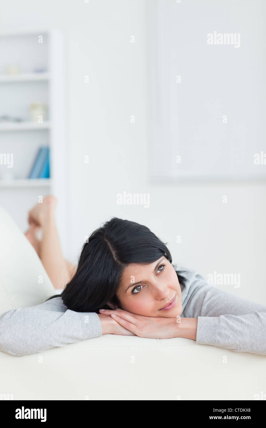 Woman on a sofa with her head resting on her arms Stock Photo - Alamy