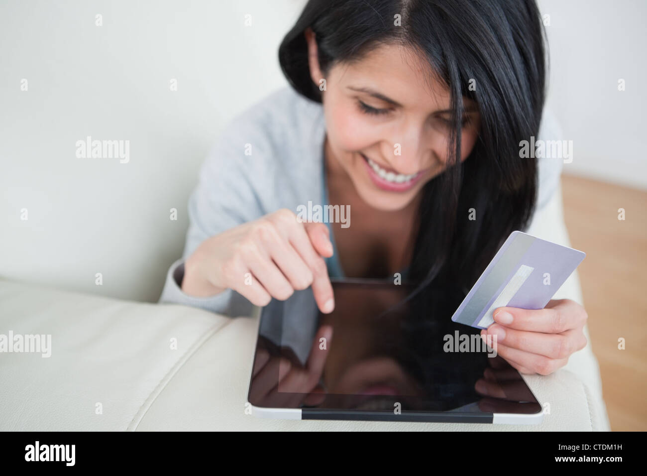Woman touching a tactile tablet and holding a credit card Stock Photo ...