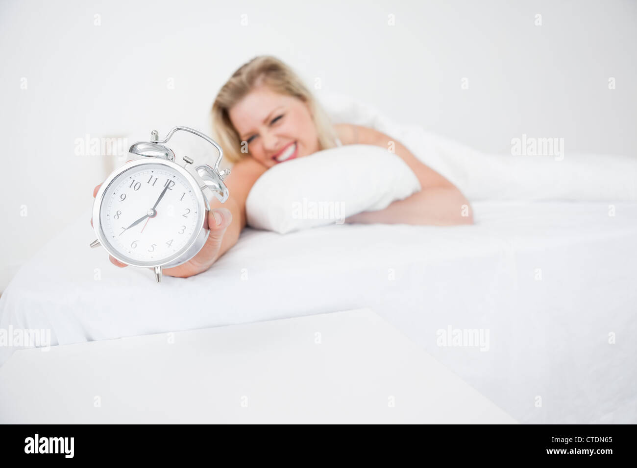 Woman getting her alarm clock Stock Photo - Alamy