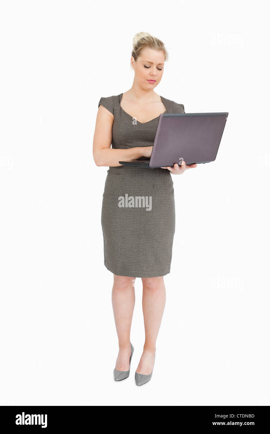 Woman standing while holding a laptop Stock Photo - Alamy
