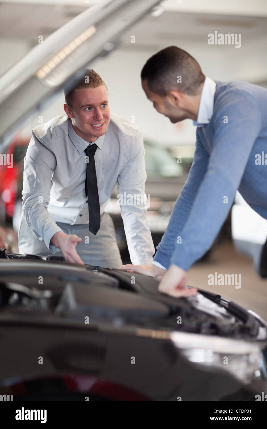 Two men looking at a car engine Stock Photo - Alamy