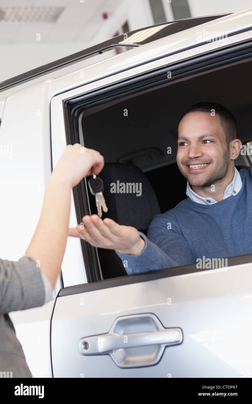 Smiling man in a car receiving a car key Stock Photo - Alamy