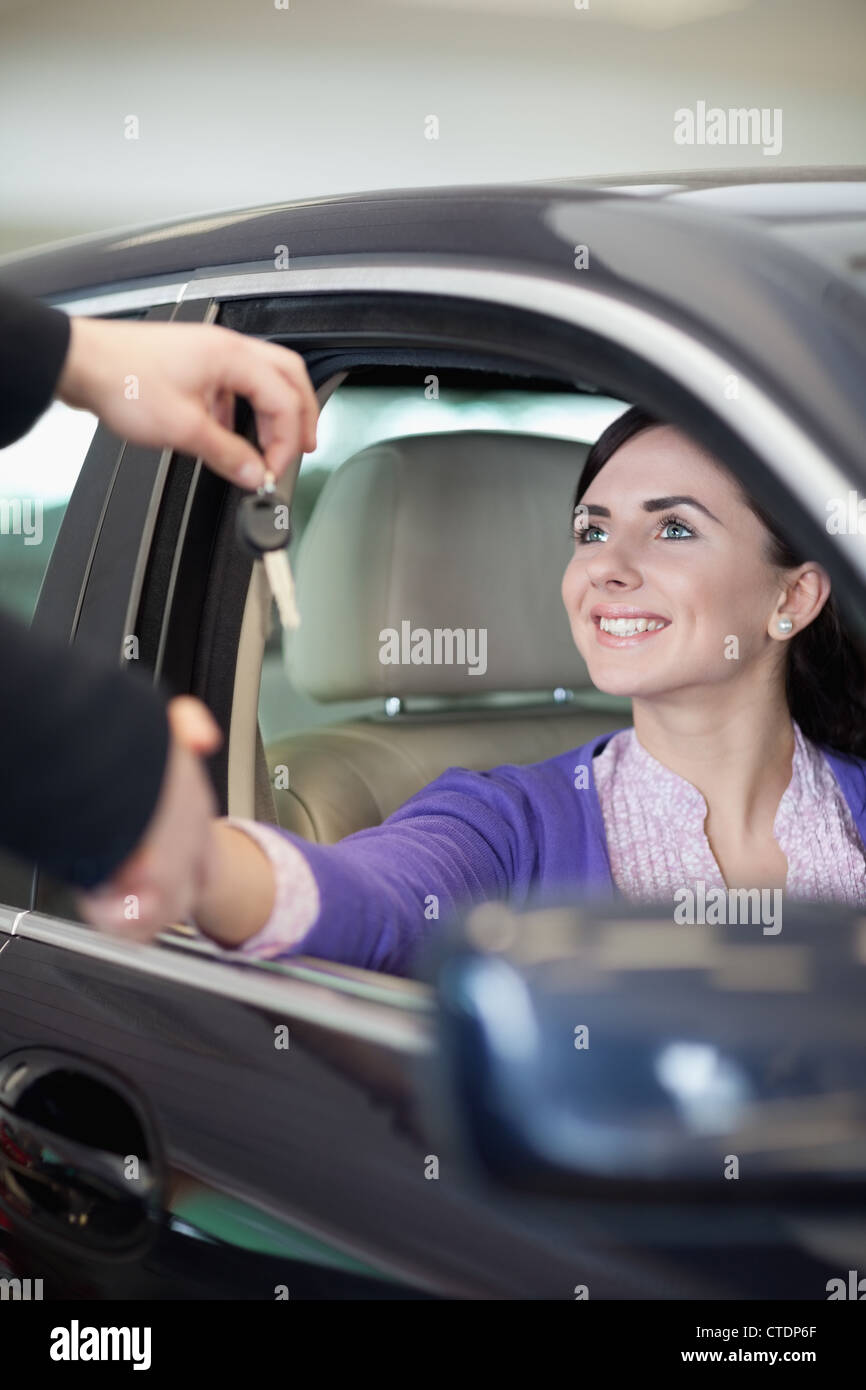Woman smiling in a car while shaking hand Stock Photo - Alamy