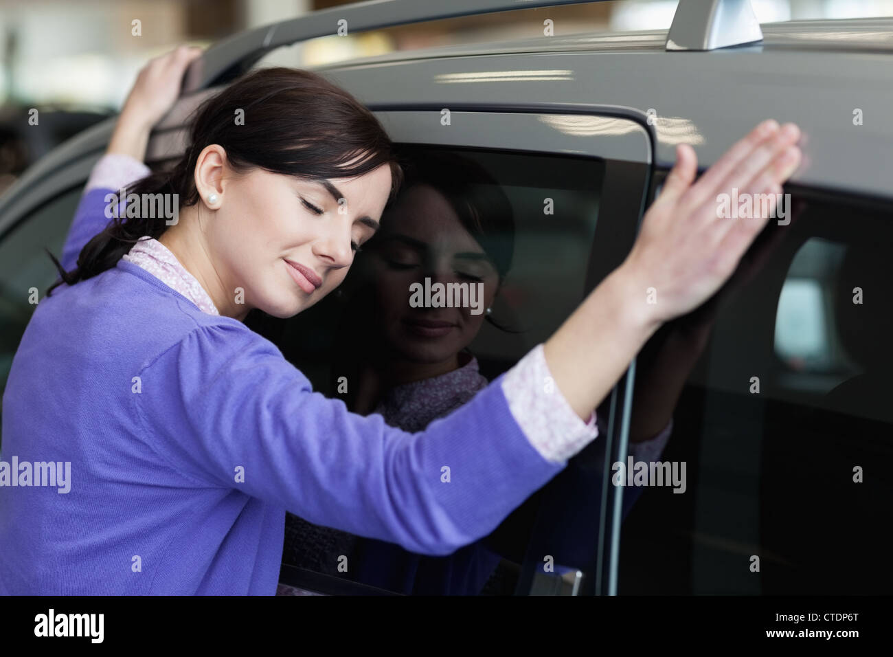 Woman hugging a grey car Stock Photo - Alamy