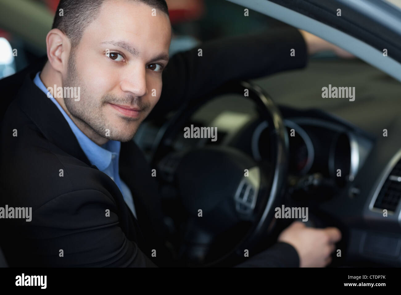 Man sitting on a car while turning on the engine Stock Photo - Alamy