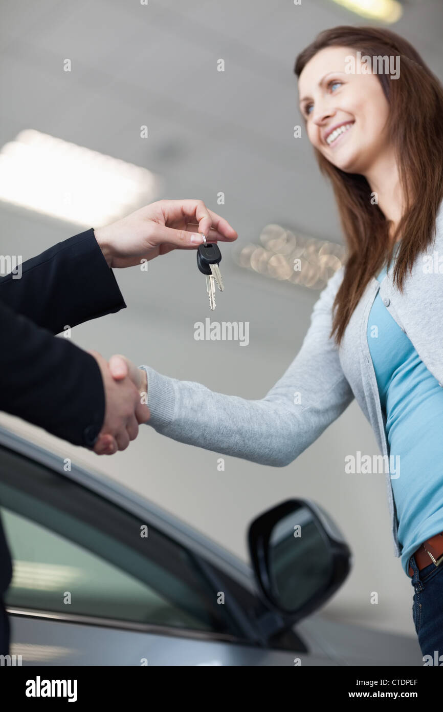 Woman receiving car keys while shaking hand Stock Photo - Alamy