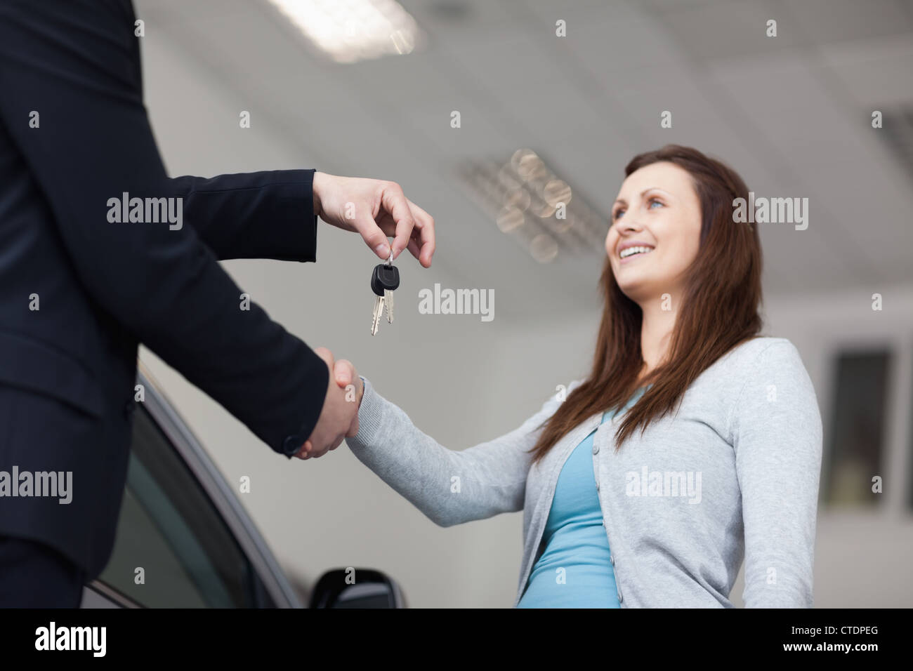 Client receiving car keys while shaking hand Stock Photo - Alamy
