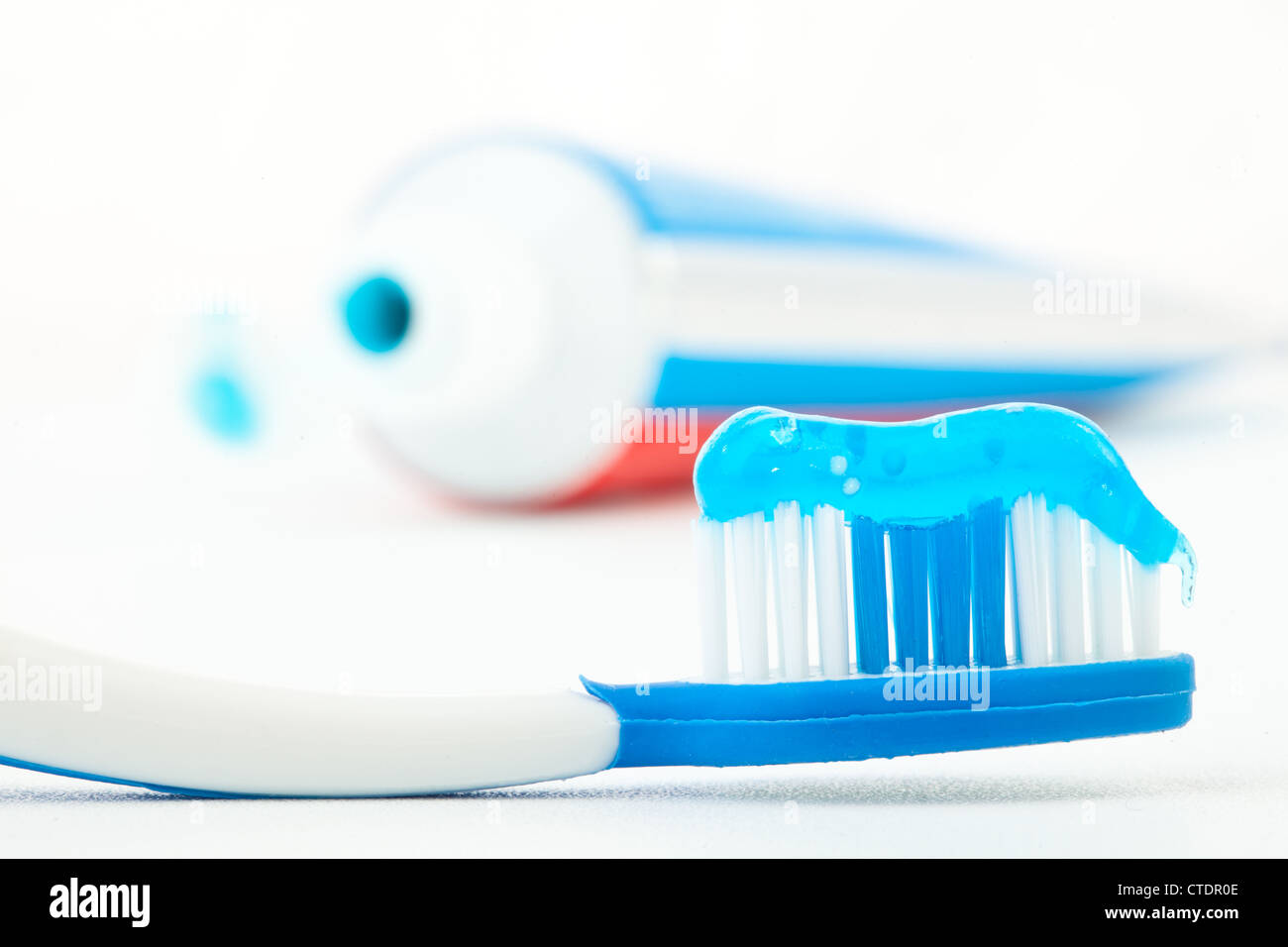 Toothbrush with blue toothpaste next to a tube of toothpaste Stock ...