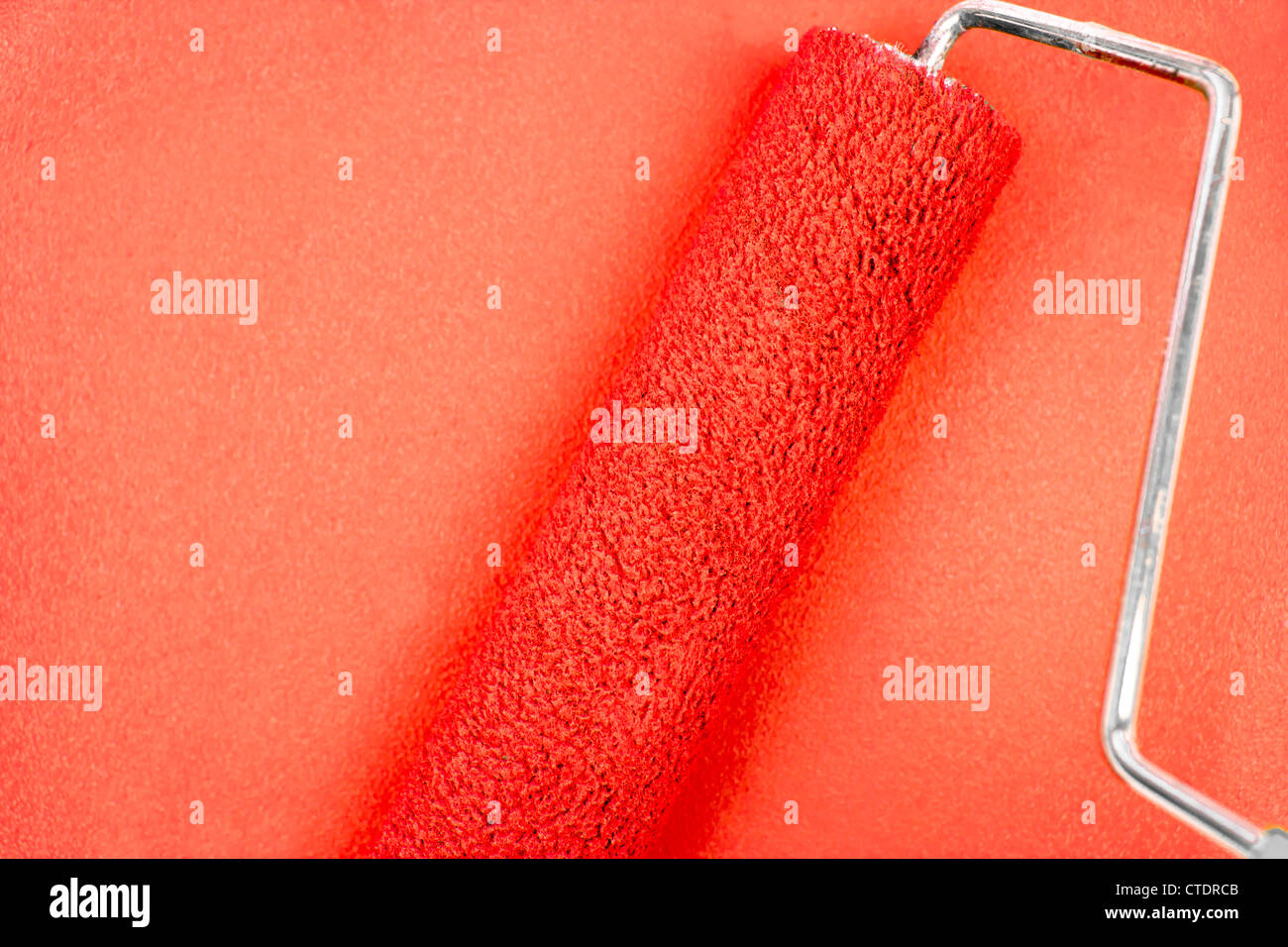 Red background with a paint roller Stock Photo - Alamy