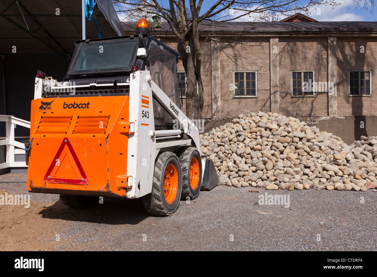 Power machine ready to move rocks in summer Stock Photo - Alamy
