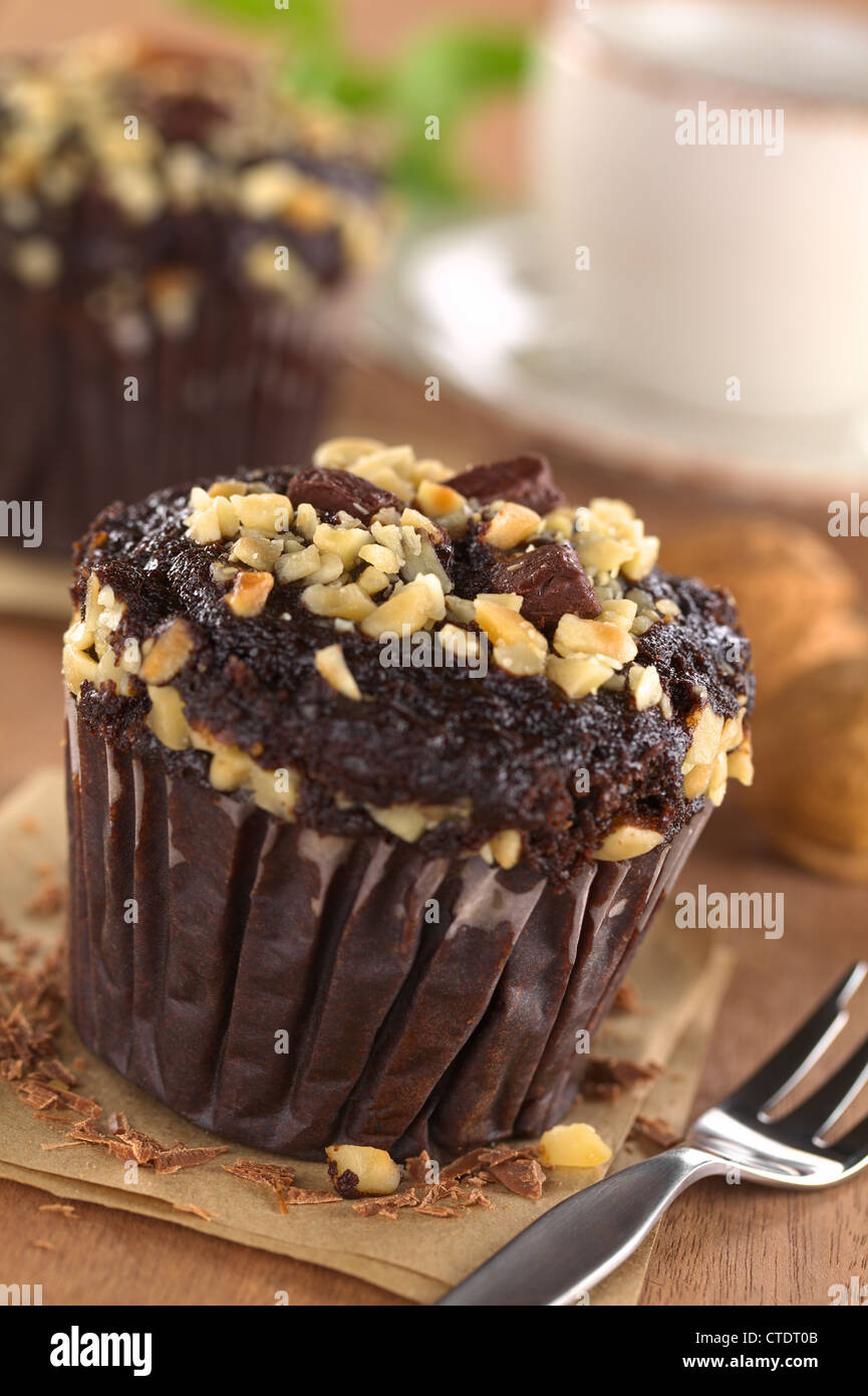 Chocolate-walnut muffins with coffee cup in the back (Selective Focus ...