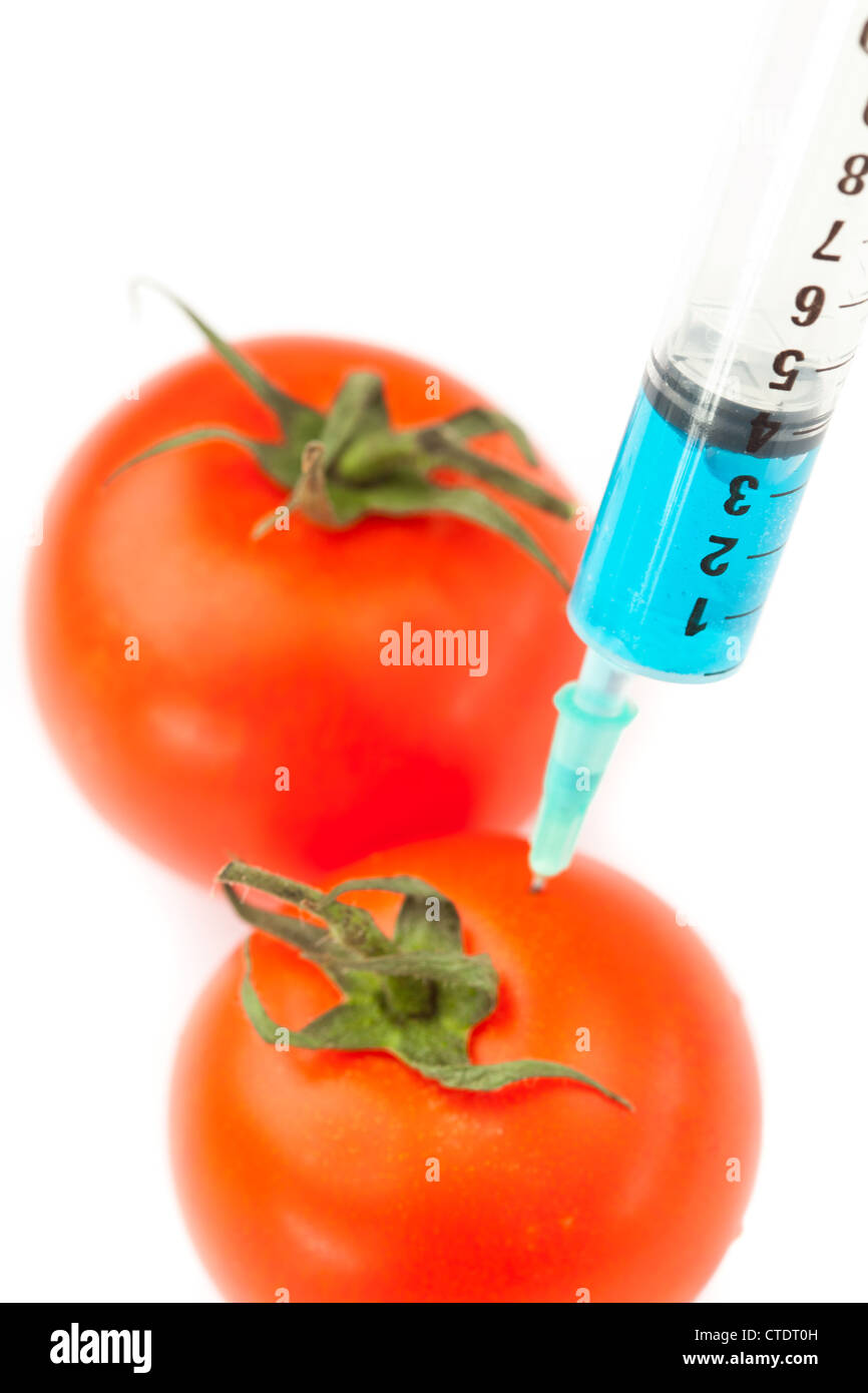 Syringe pricking a tomato Stock Photo - Alamy