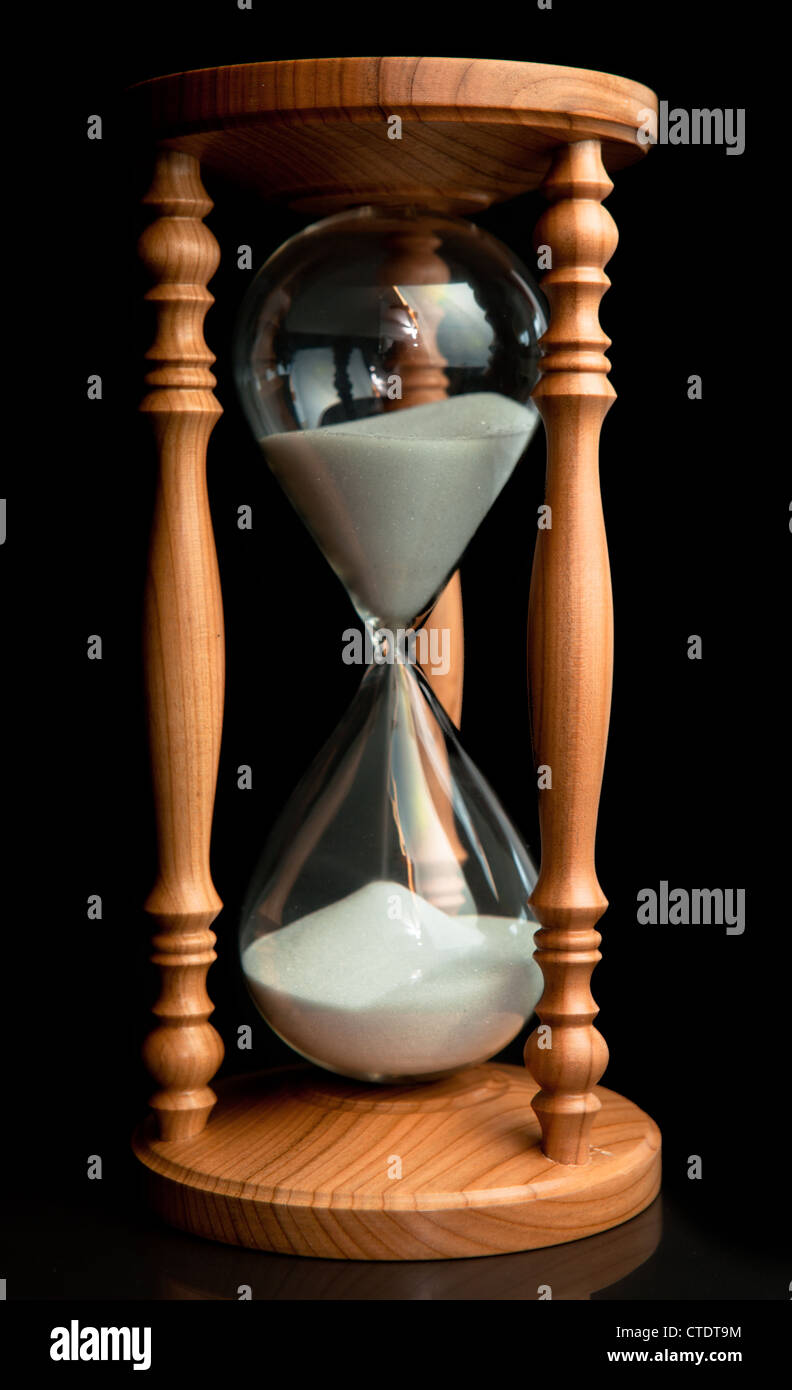 Sand flowing inside of hourglass Stock Photo - Alamy