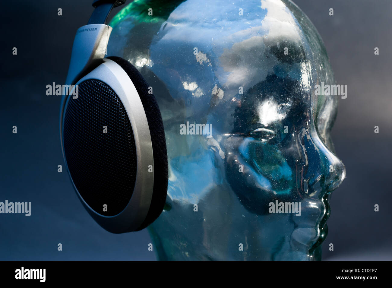 Glass head wearing headphones Stock Photo - Alamy