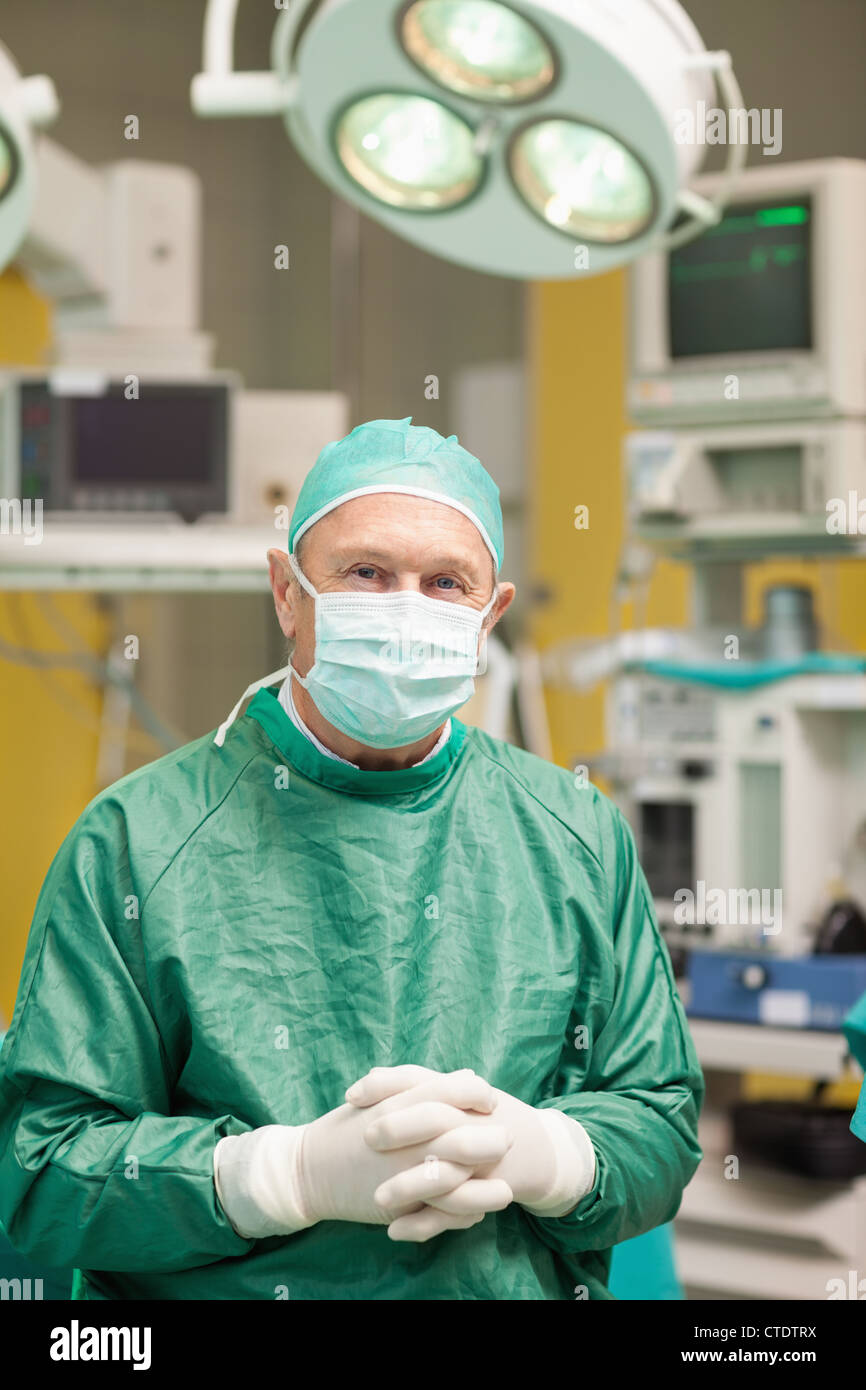 Surgeon smiling while crossing his hands Stock Photo - Alamy