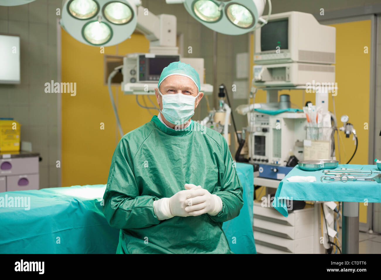 Surgeon smiling while joining his hands together Stock Photo - Alamy