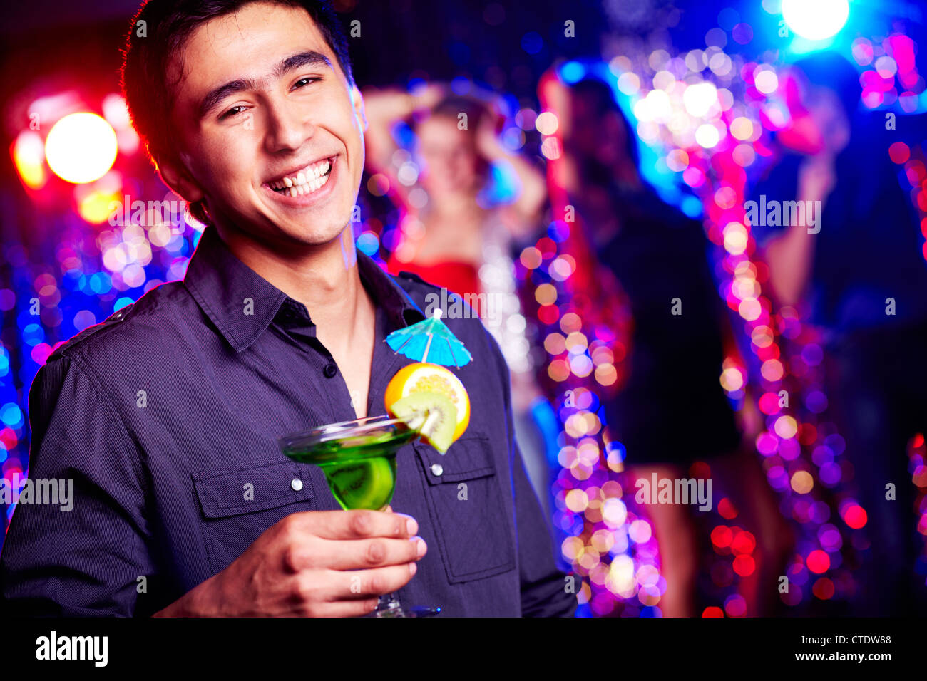 Image of happy guy holding cocktail at party Stock Photo - Alamy