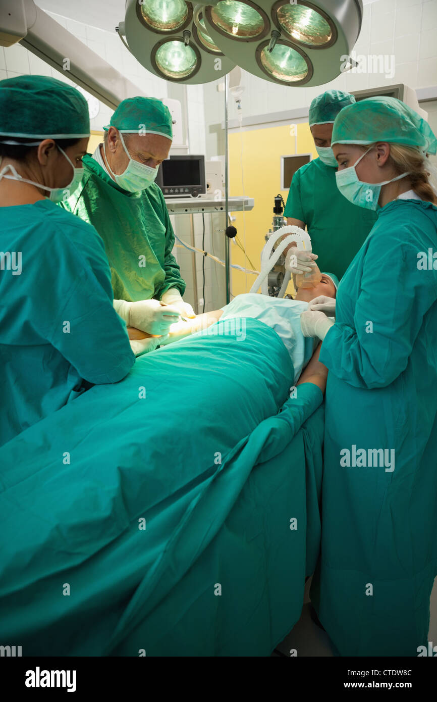 Patient being operated by a team of surgeon Stock Photo - Alamy