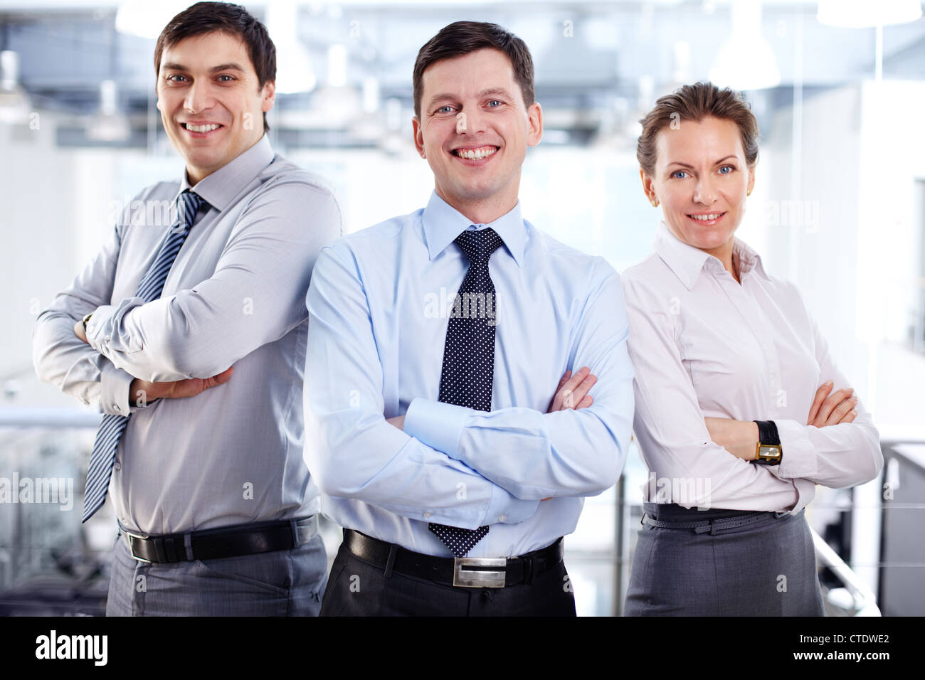 Elegant business team standing cross-armed expressing positivity and ...