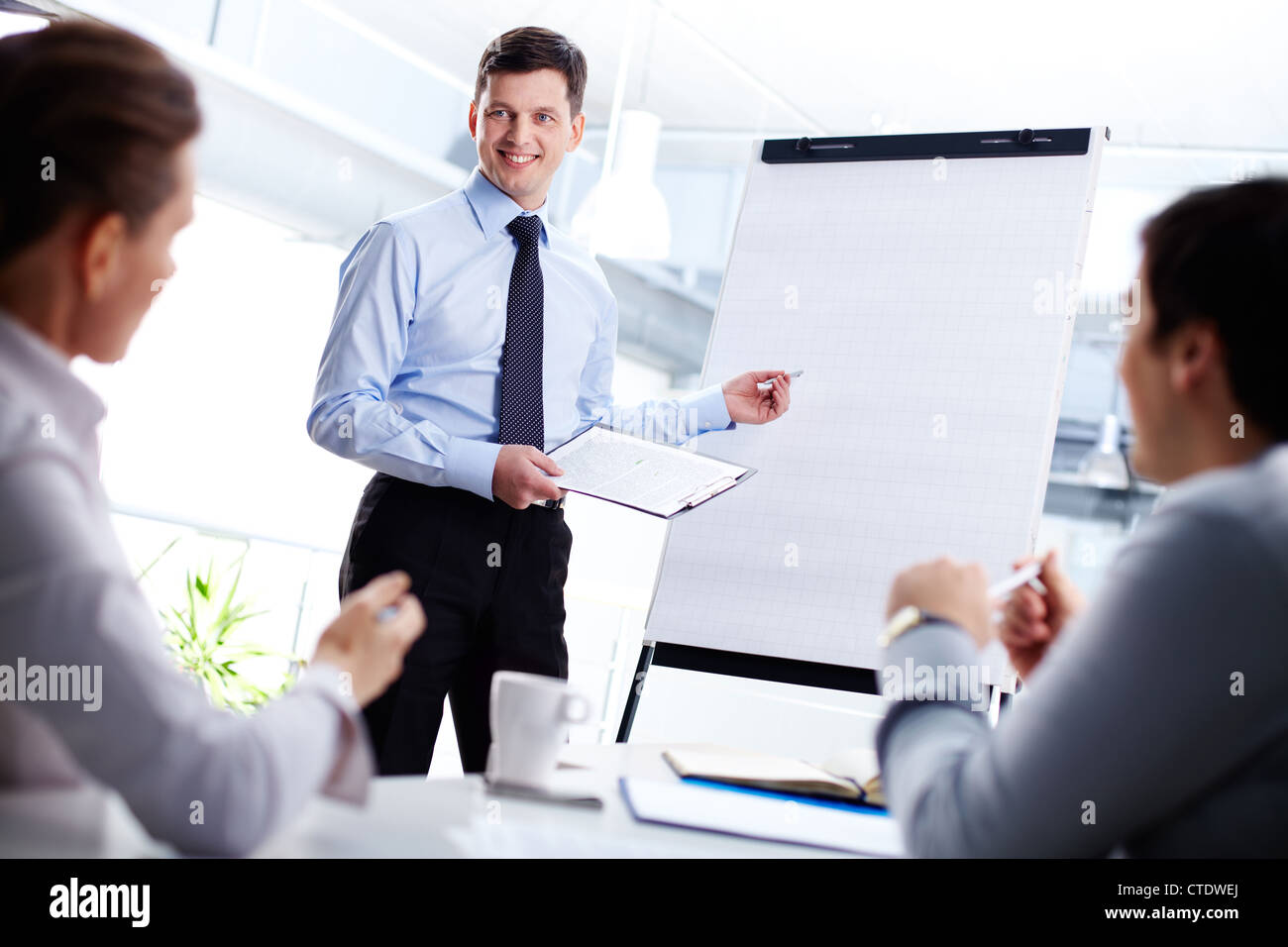 Cheerful office worker pointing at the blank whiteboard making a ...