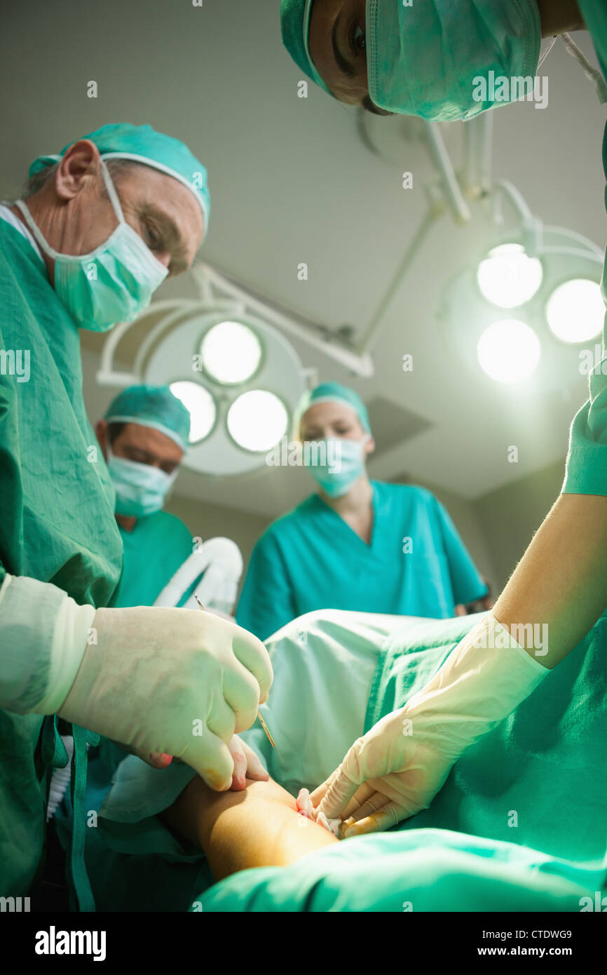 Team of surgeons using scalpel to open a patient Stock Photo - Alamy
