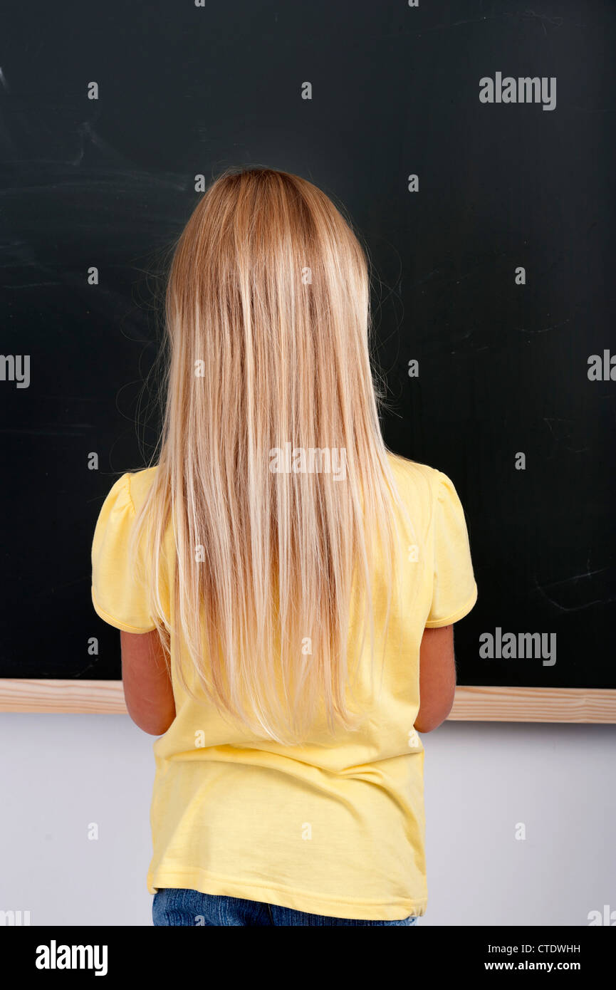 back view of a little girl writing on a chalkboard Stock Photo - Alamy