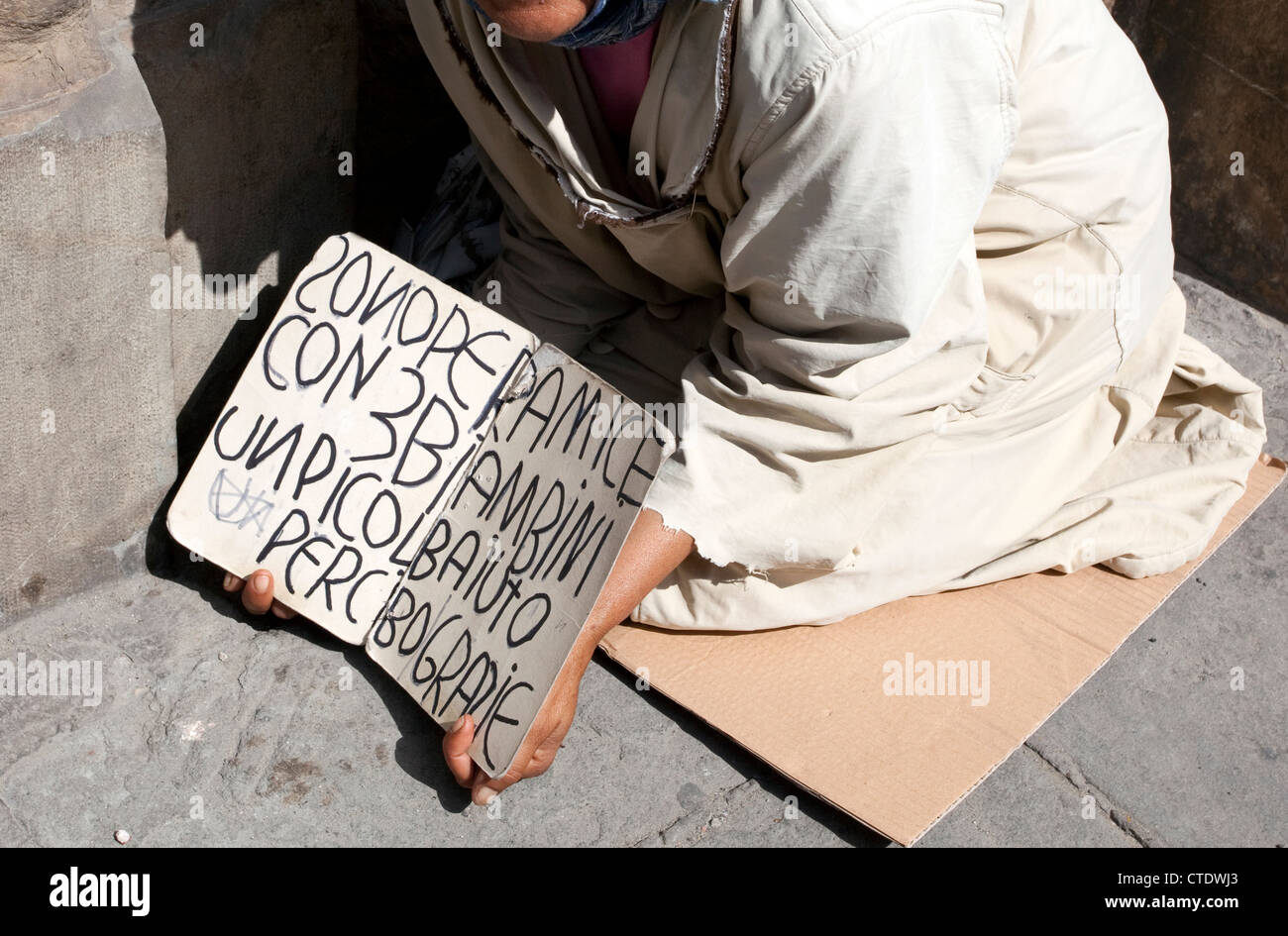 Beggar in street in central Florence, Italy - sign says three children ...