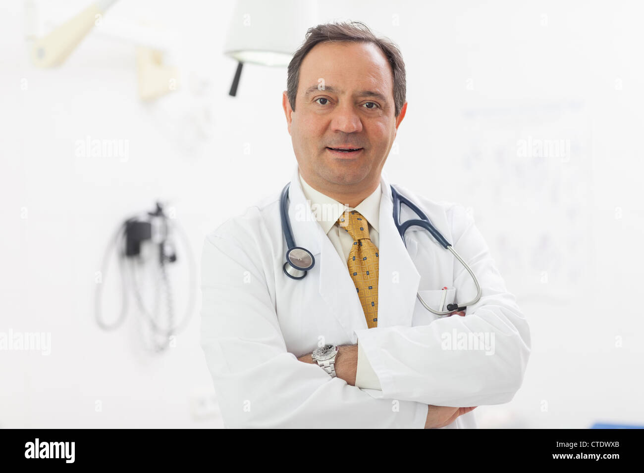 Doctor crossing his arms while smiling Stock Photo - Alamy