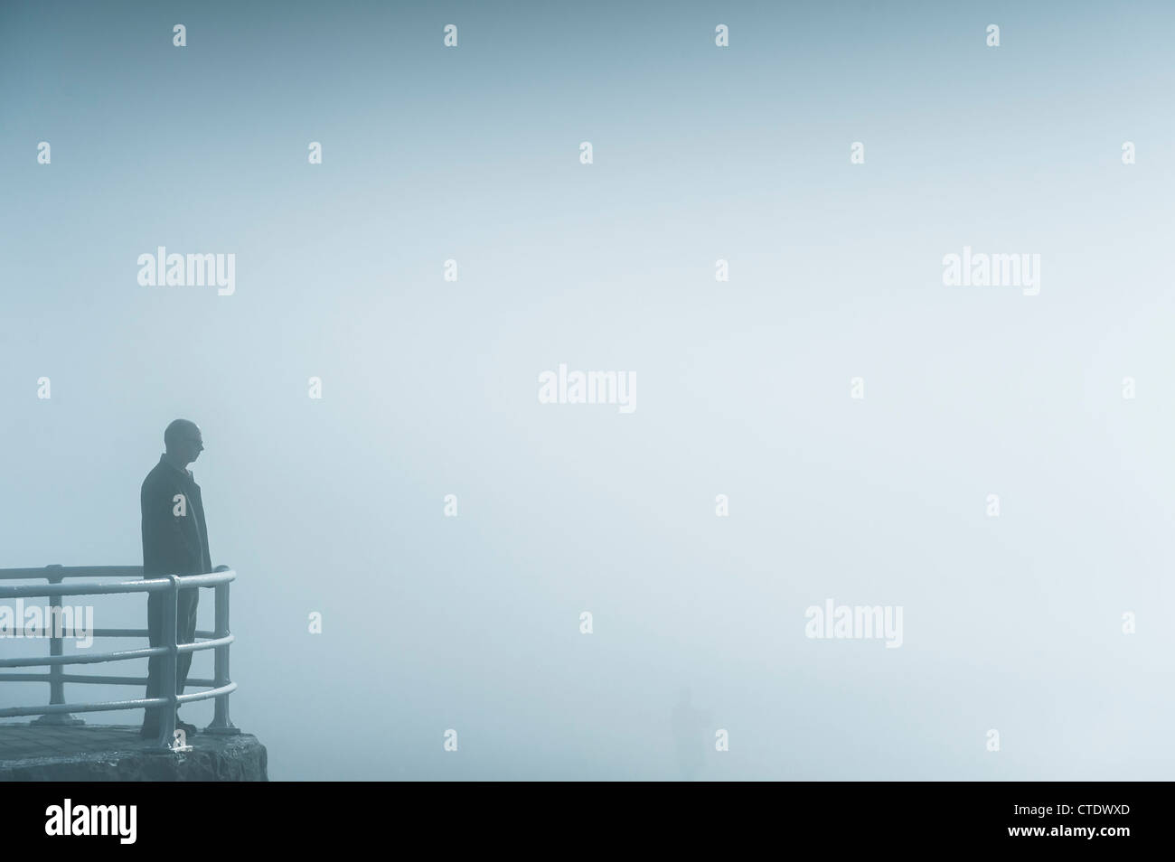 A man standing alone in the fog foggy mist misty weather UK - seaside ...