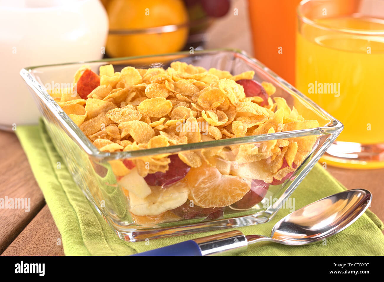 Glass bowl full of fresh fruits (banana, apple, mandarin, grapes) with ...
