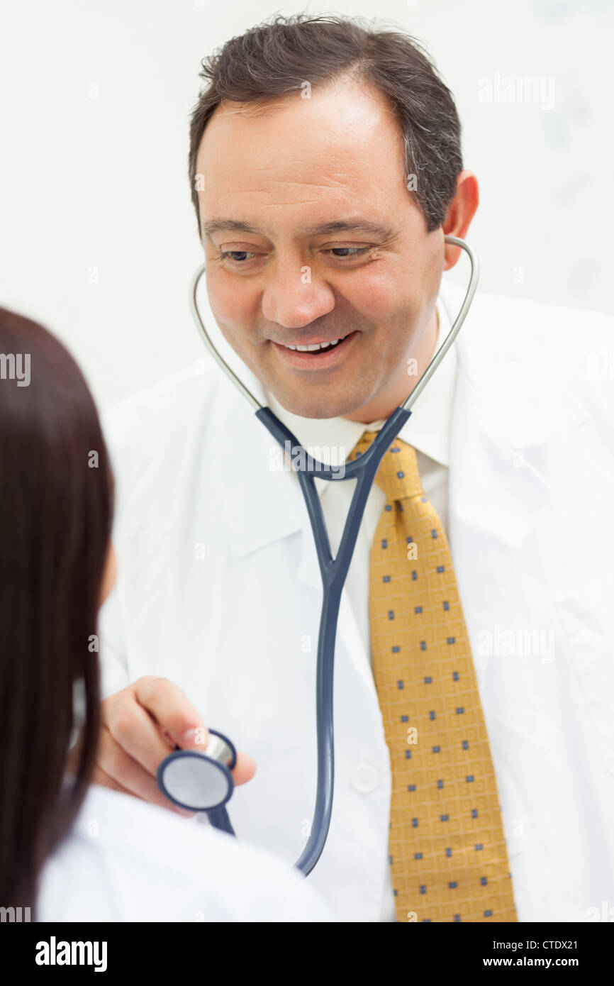 Doctor holding a stethoscope with a patient Stock Photo - Alamy