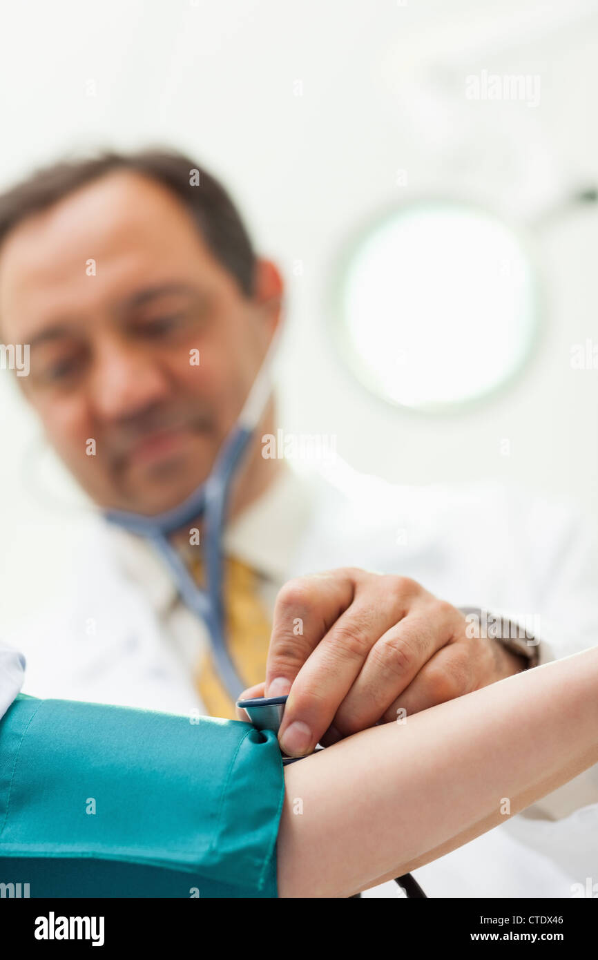 Doctor placing his stethoscope on the arm of his patient Stock Photo ...