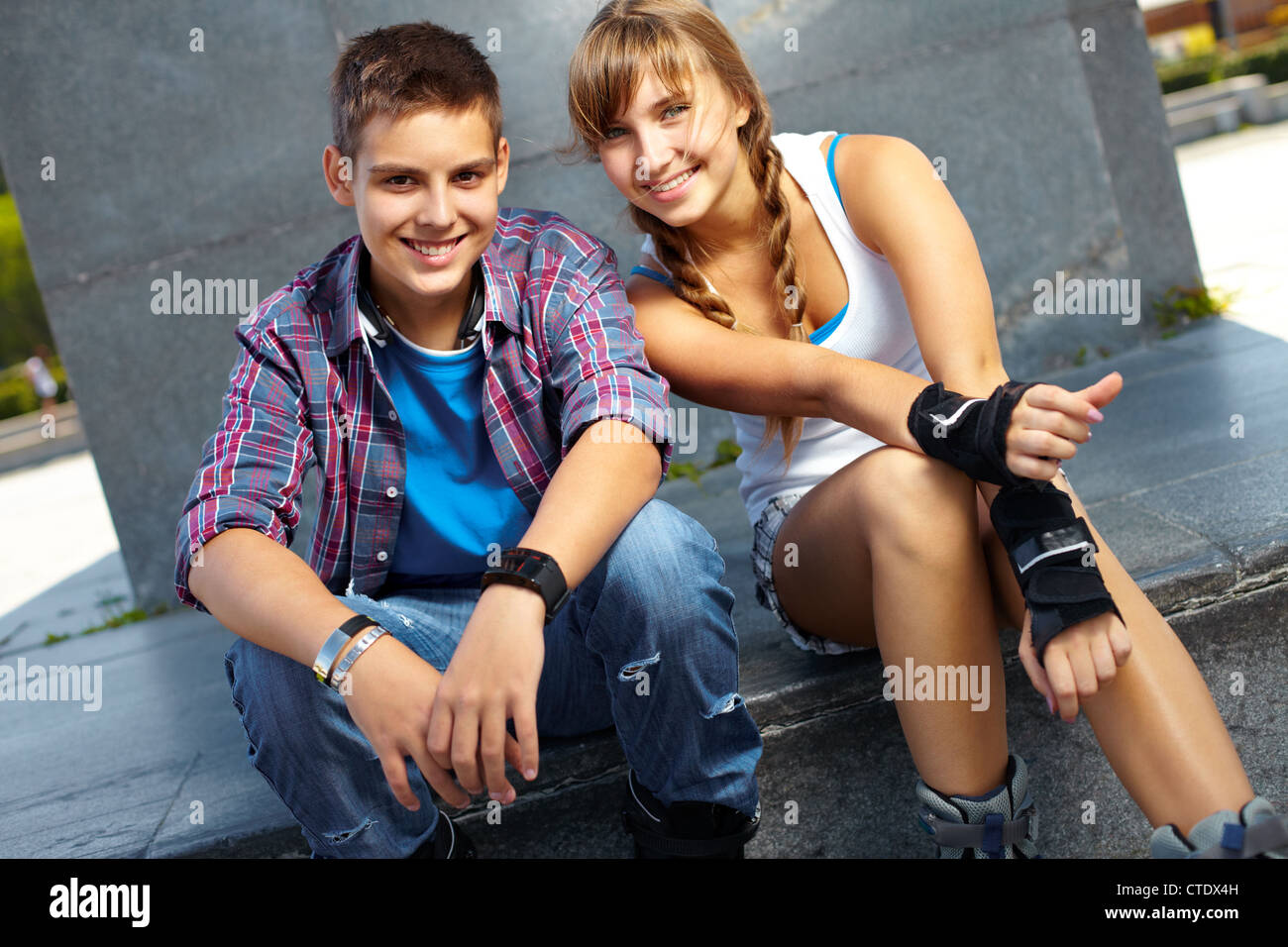Cool teenagers hanging out together, active girl wearing roller skaters ...