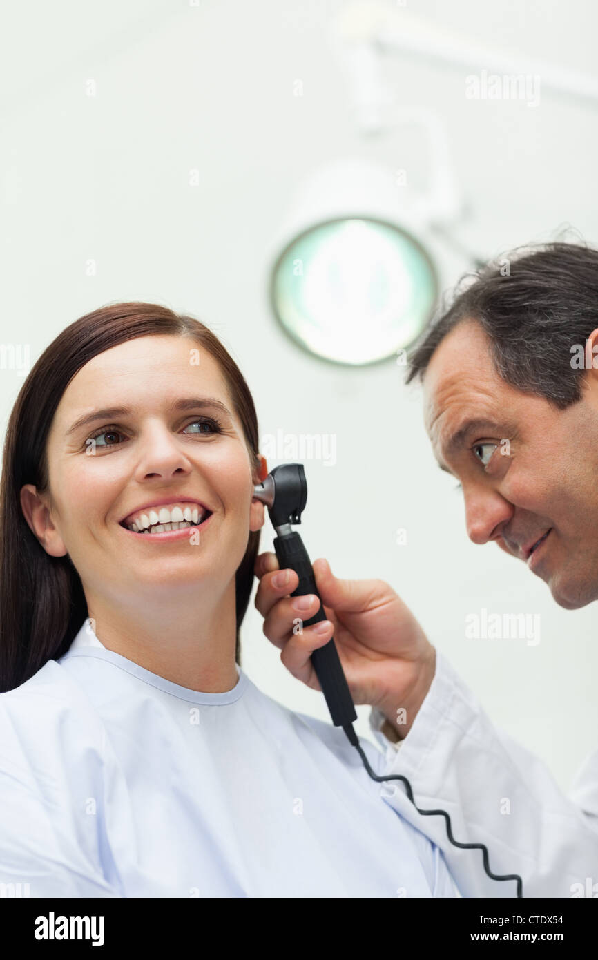 Doctor using an otoscope to look at the ear of a patient Stock Photo ...