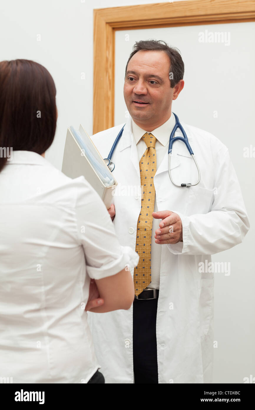 Doctor holding files while talking to a patient Stock Photo - Alamy